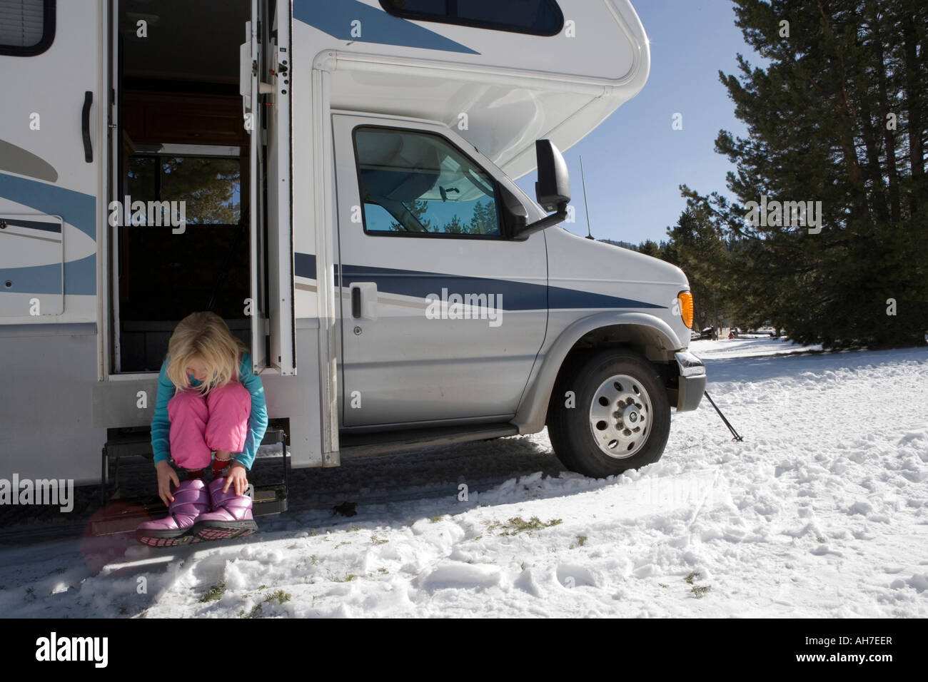 Girl sitting on the steps of a recreational vehicle and putting on her ...