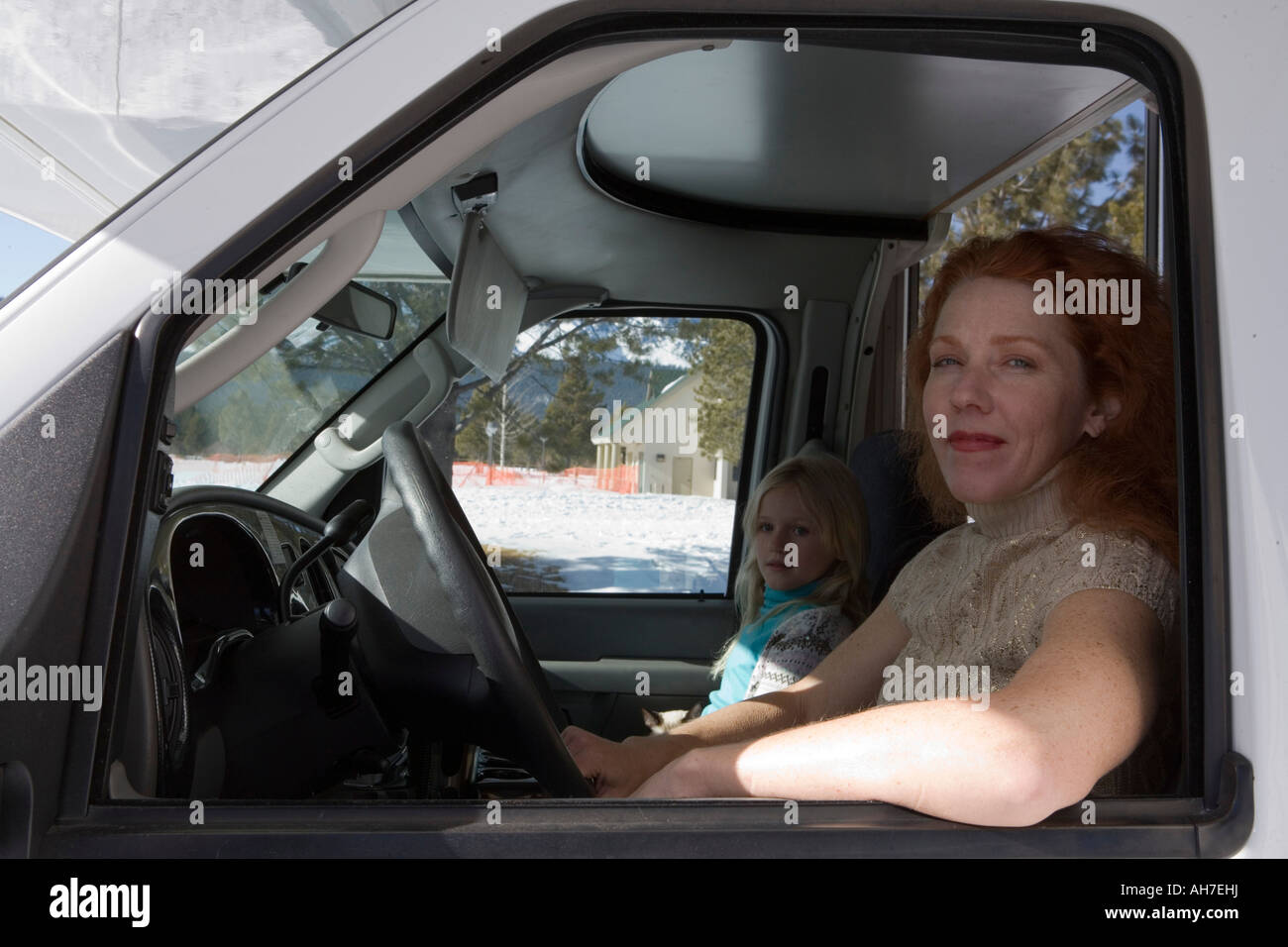Mature woman driving a recreational vehicle with her daughter sitting ...
