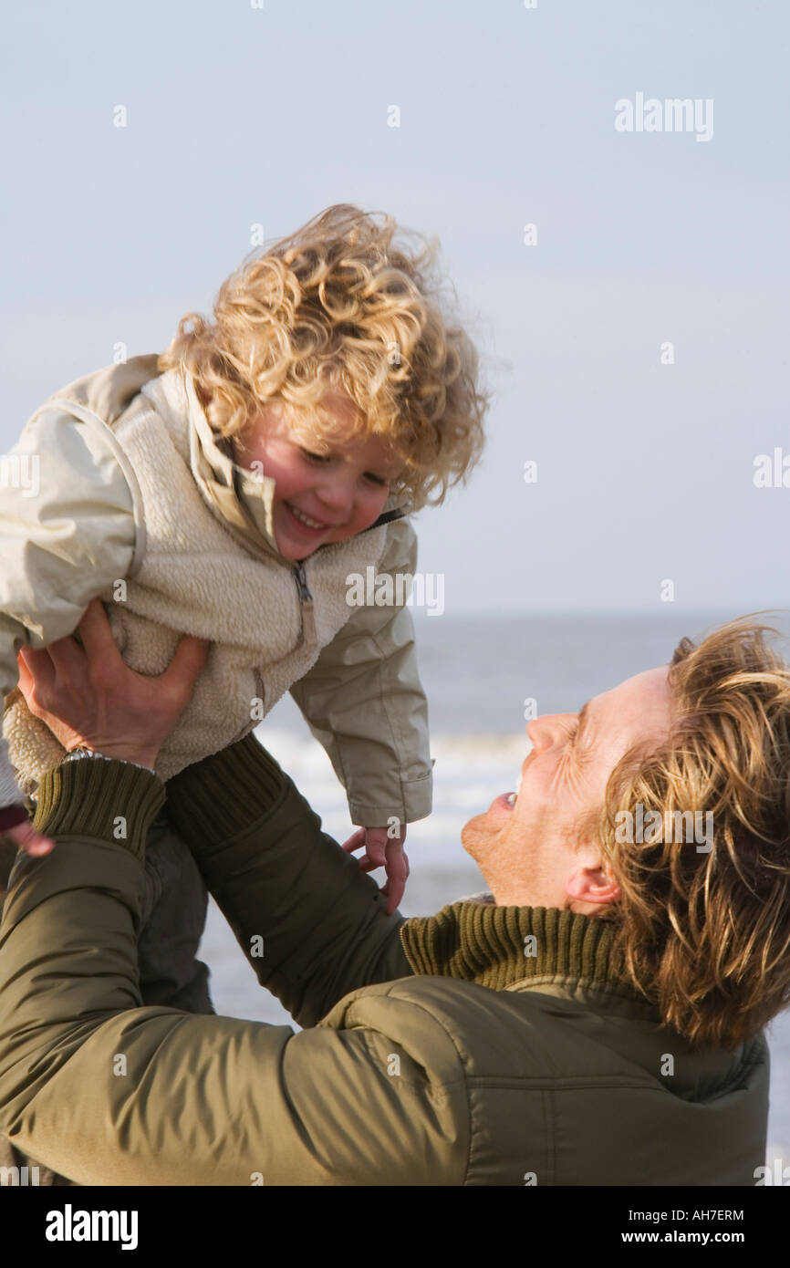 Mid adult man lifting his son in the air Stock Photo - Alamy