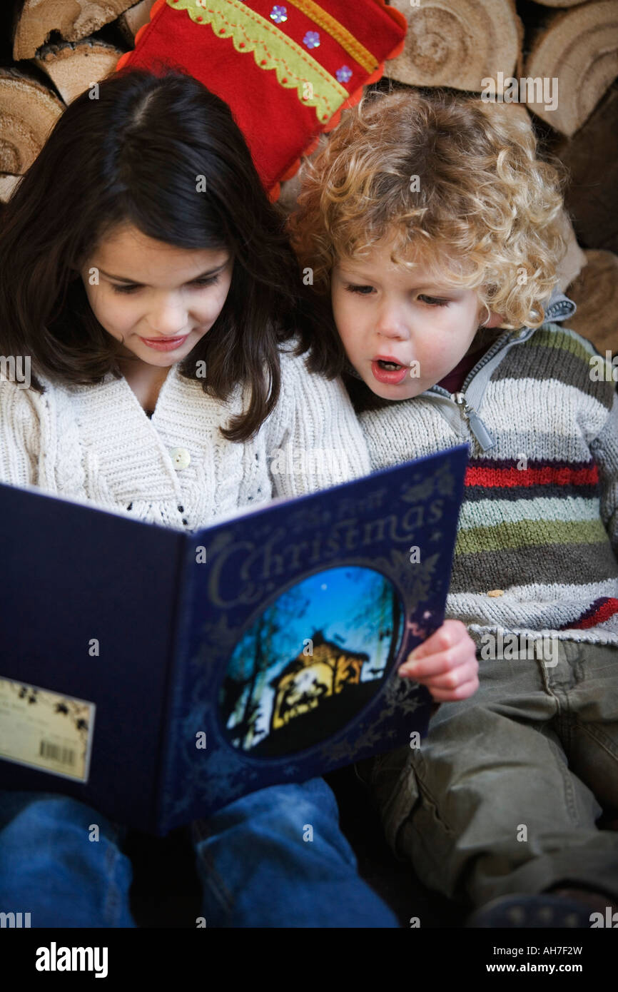 Girl and boy reading a book Stock Photo - Alamy