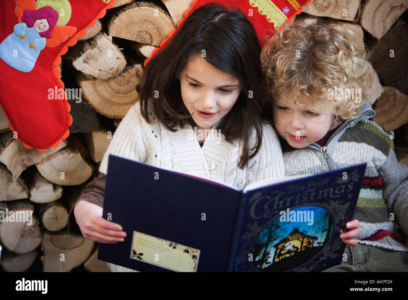 Girl and boy reading a book Stock Photo - Alamy