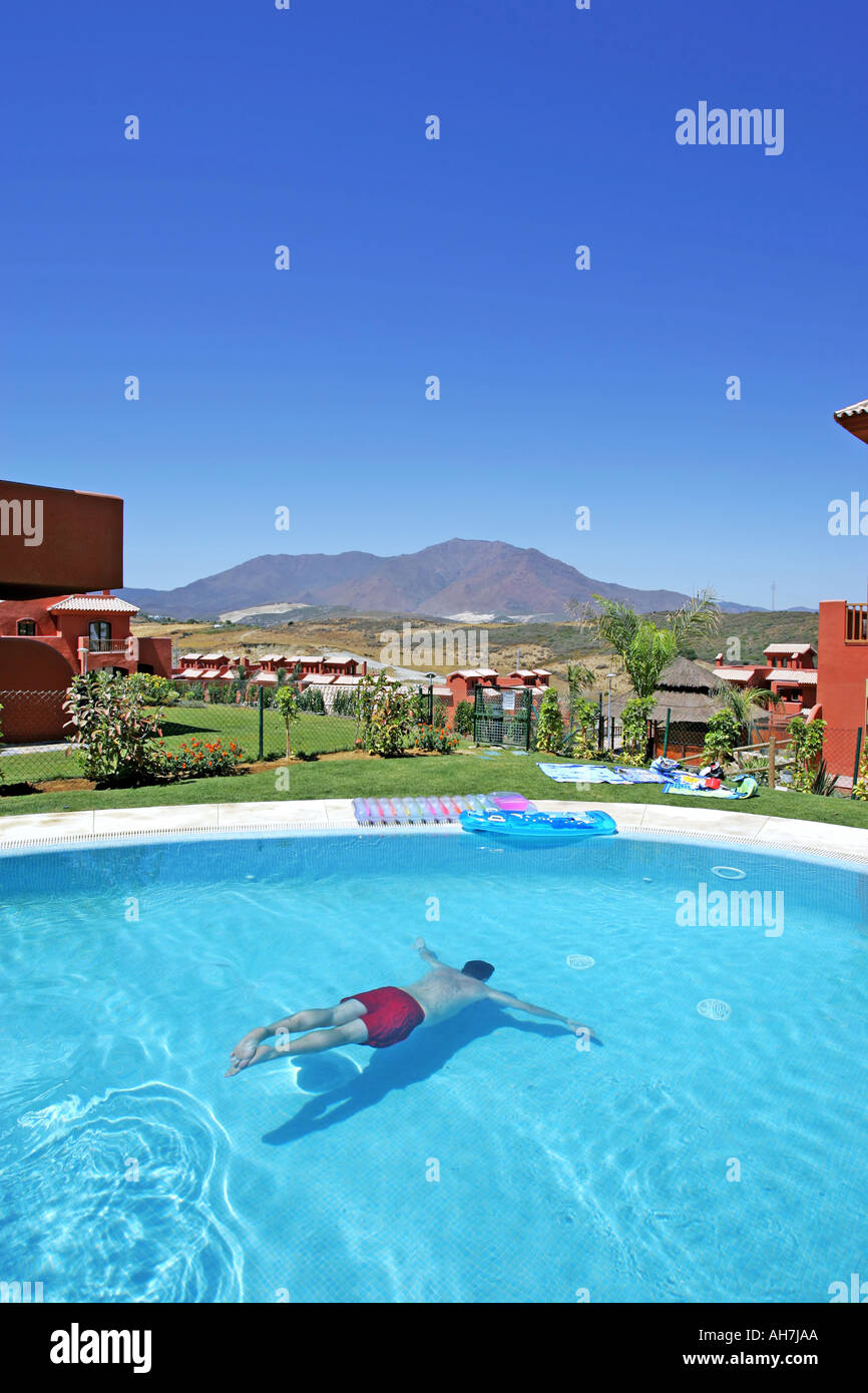 Man swimming underwater in bright sunny pool on vacation in Spain Stock ...
