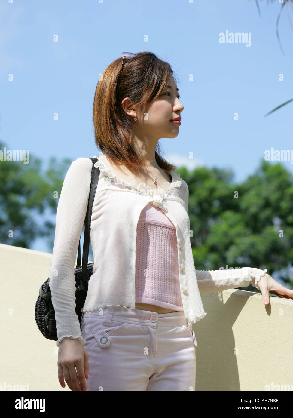 Side profile of a young woman standing against a wall Stock Photo - Alamy