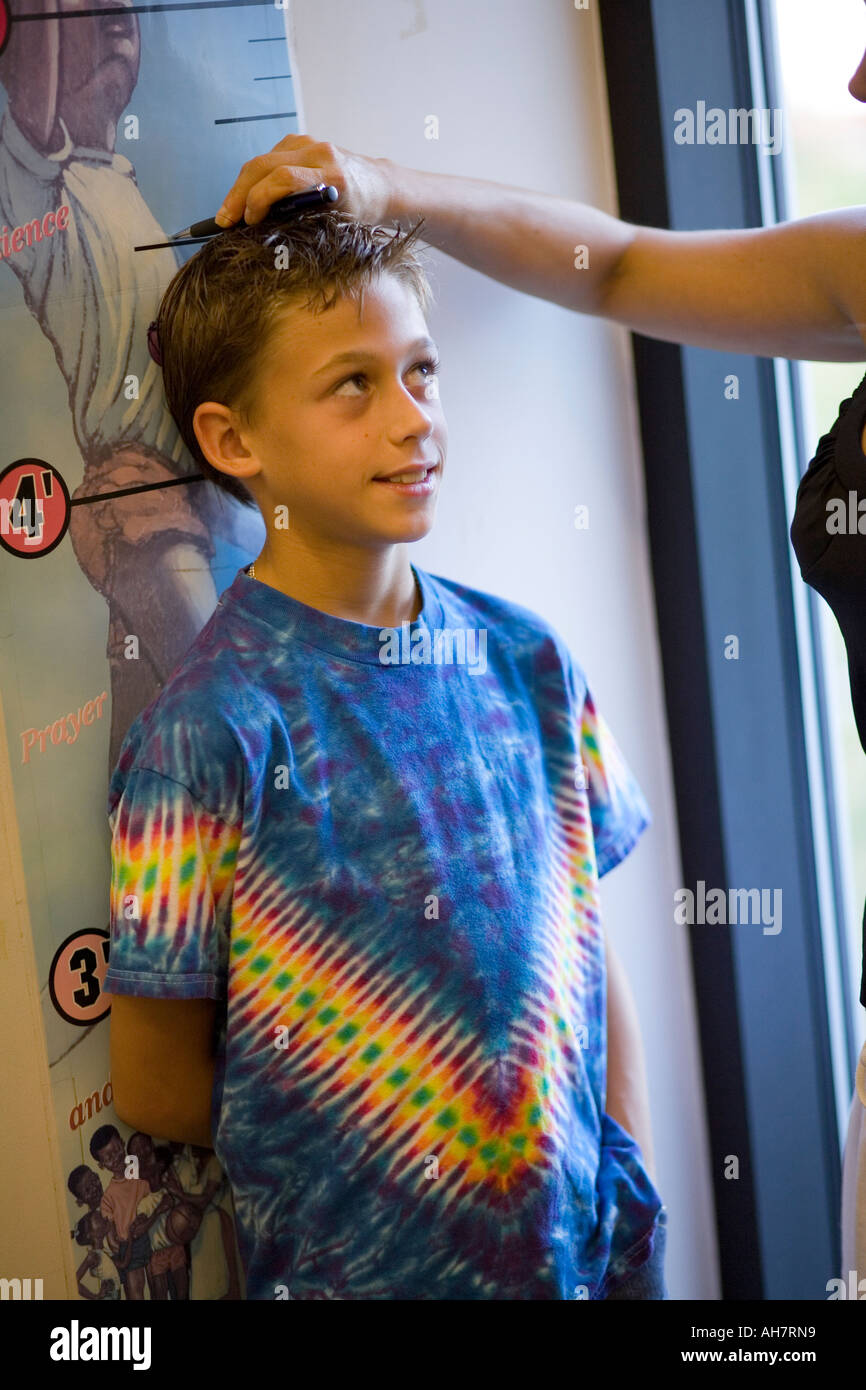 Young boy with his mother measuring his hieght Stock Photo - Alamy