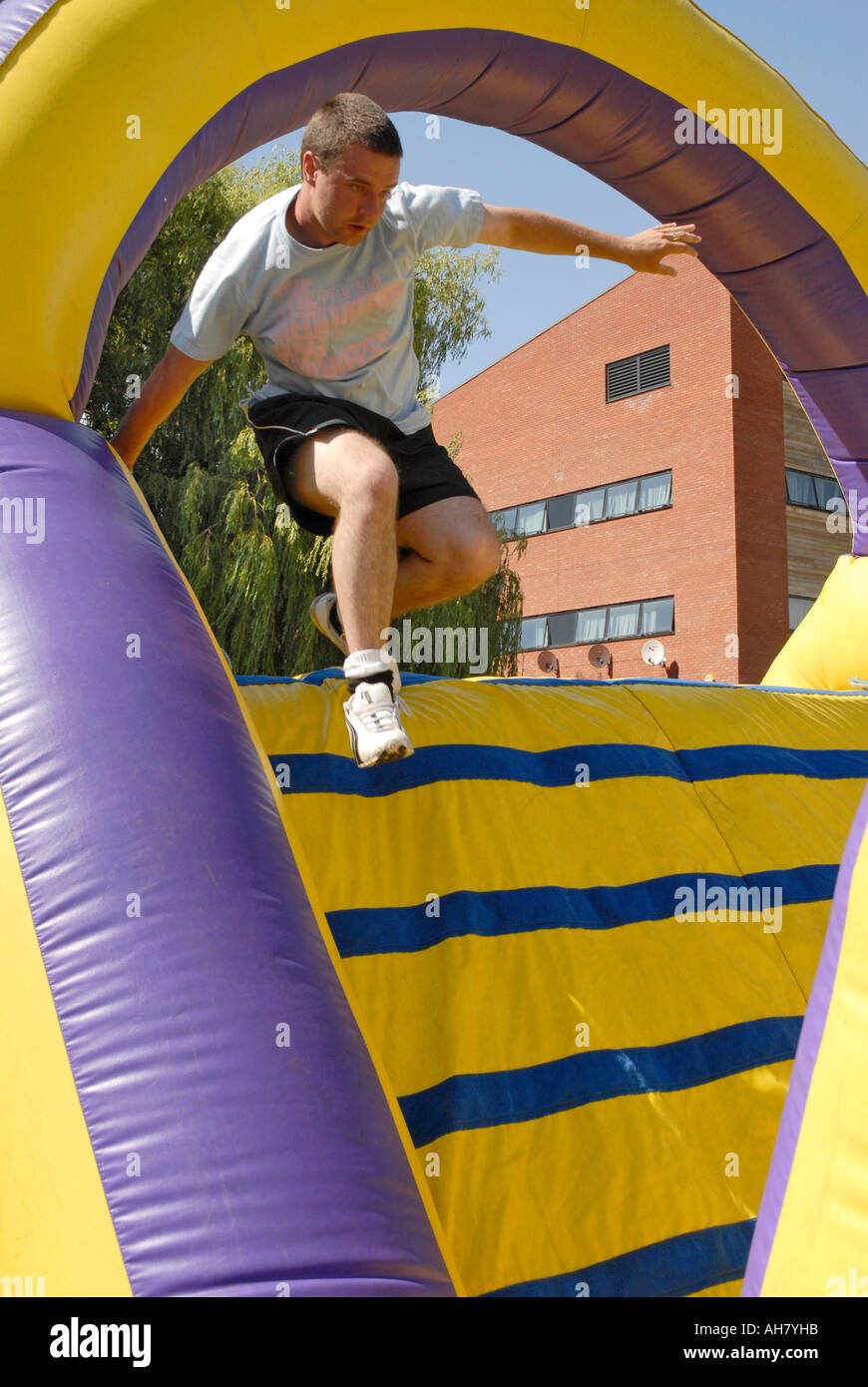 young man racing through obstacle course at local community fete Stock ...