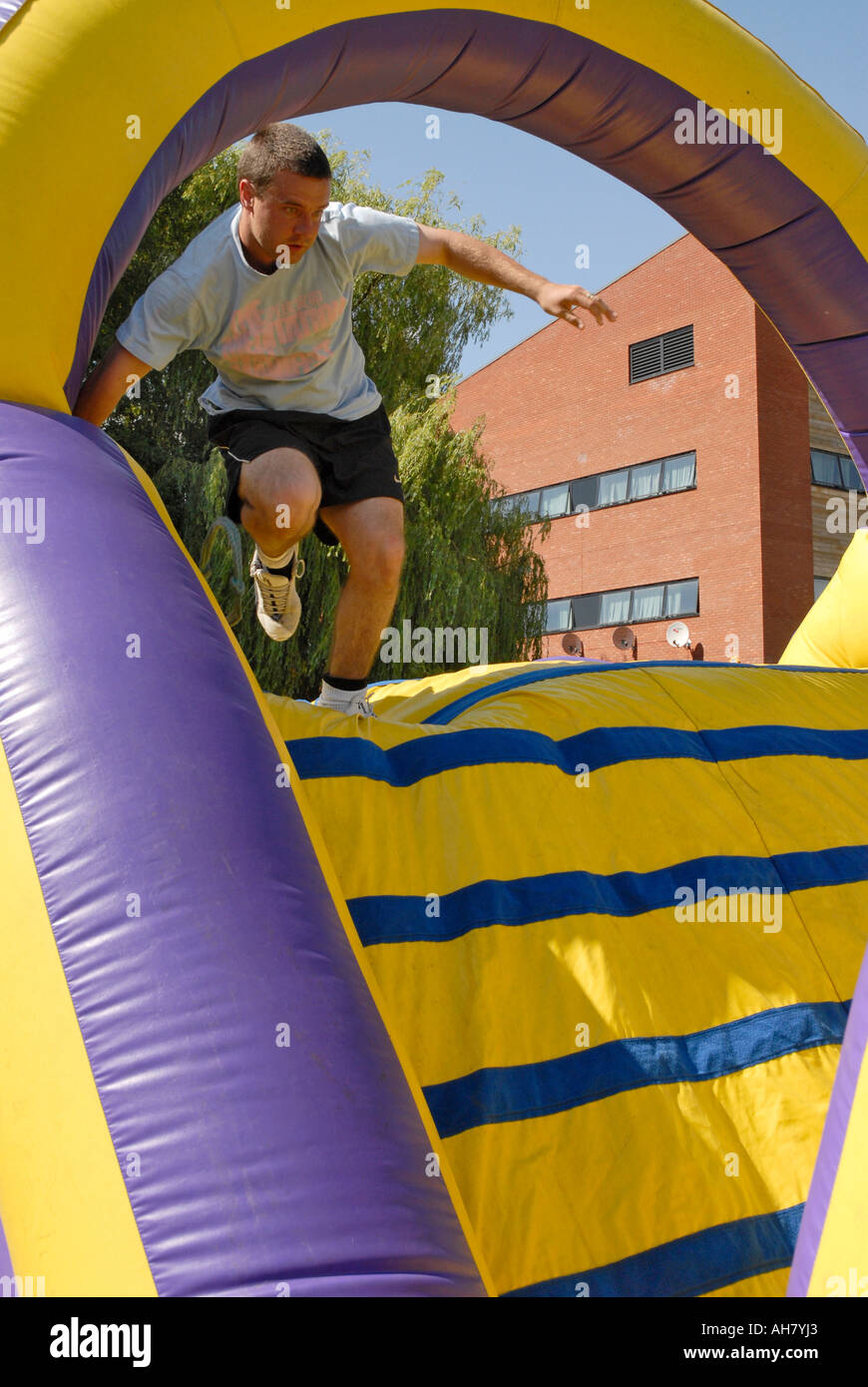 young man racing through obstacle course at local community fete Stock ...