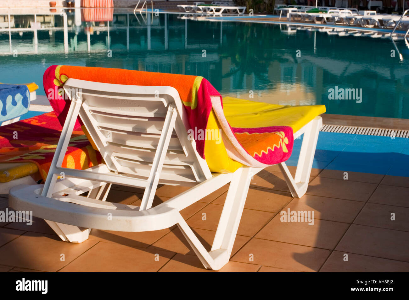 Towels on sunbed at side of pool Stock Photo - Alamy