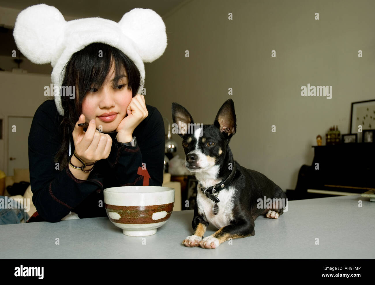 Young Woman in Fur Ears Eating with Her Dog Stock Photo - Alamy