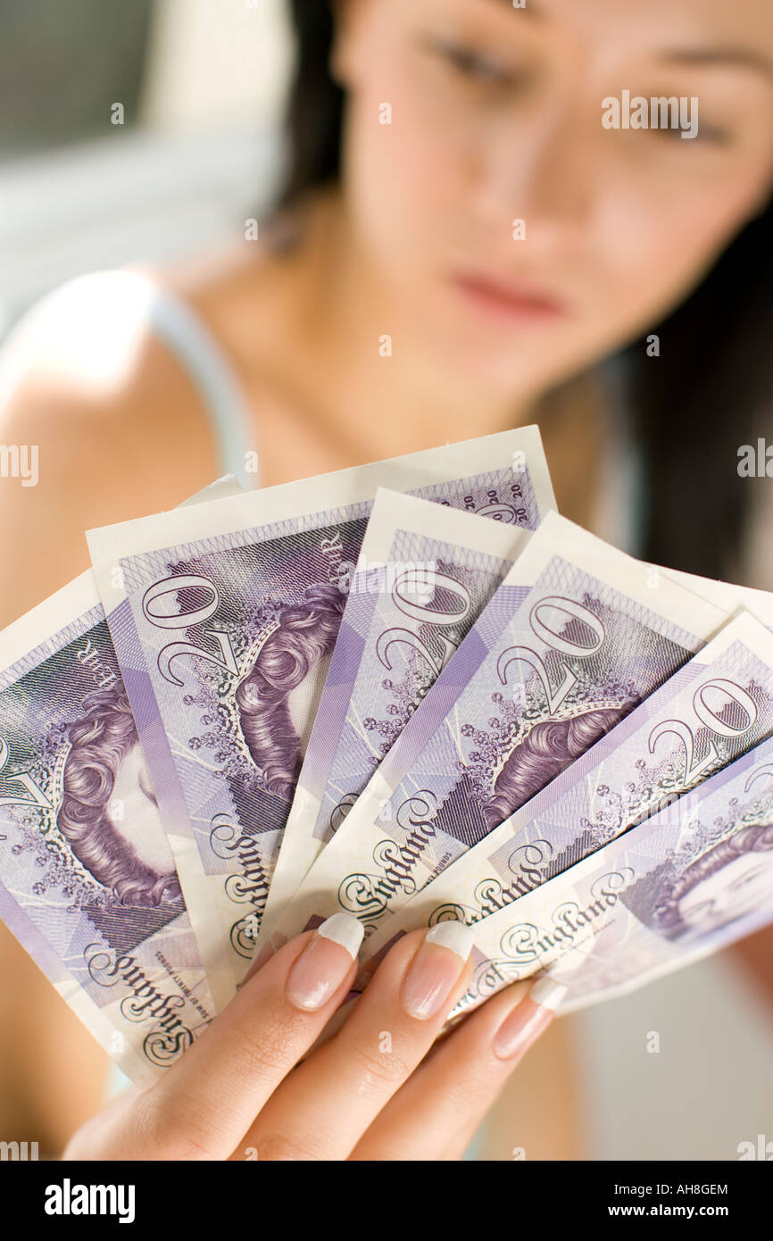 Woman holding 20 pound notes Stock Photo - Alamy
