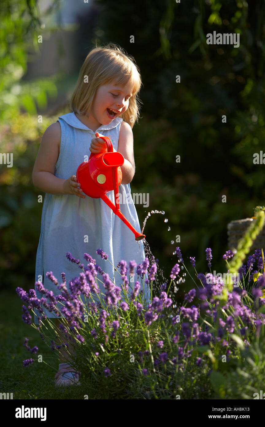 Young girl watering the garden Dorset England UK Stock Photo - Alamy