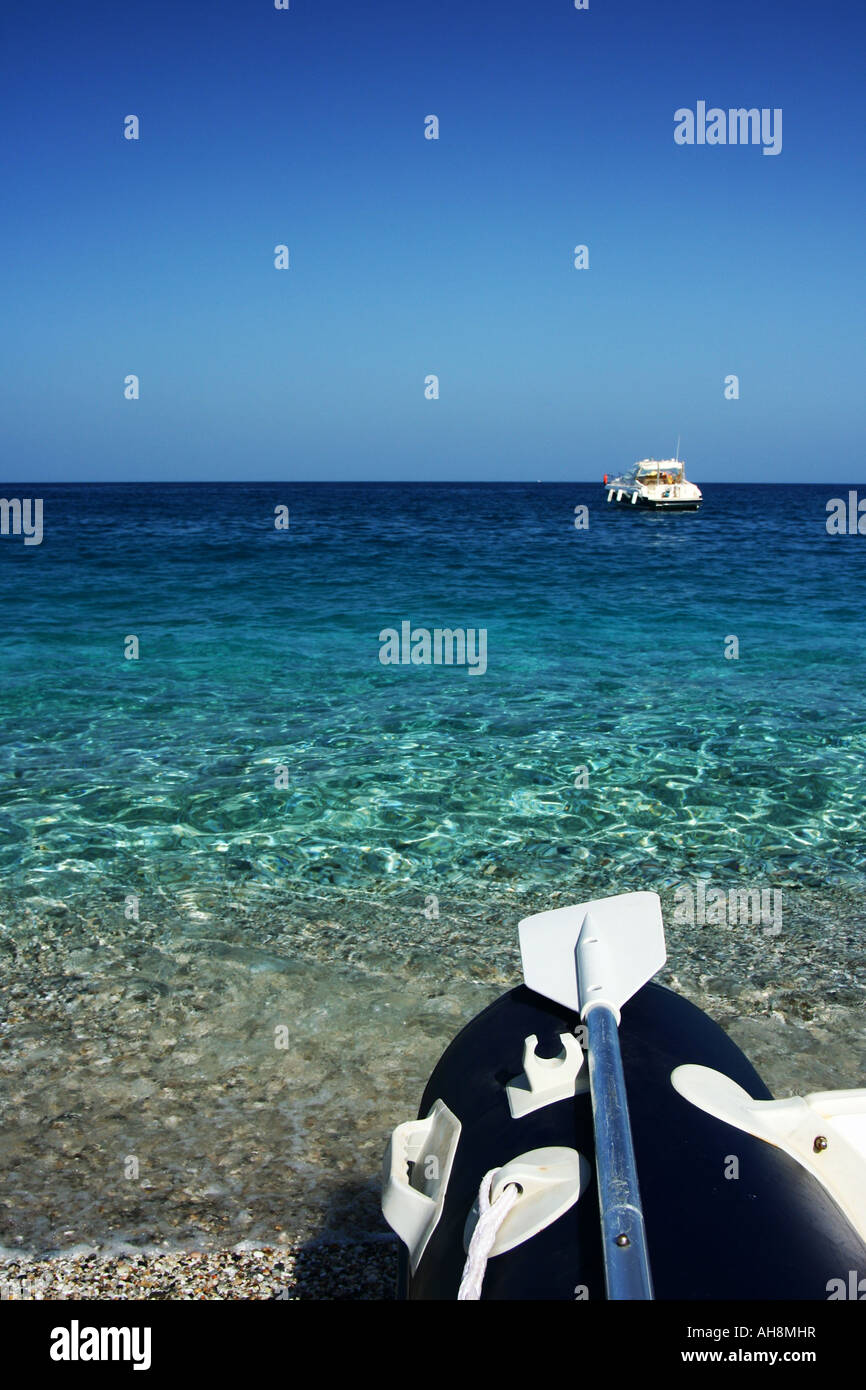 Small rowing boat lying on the beach after carrying people from a ...