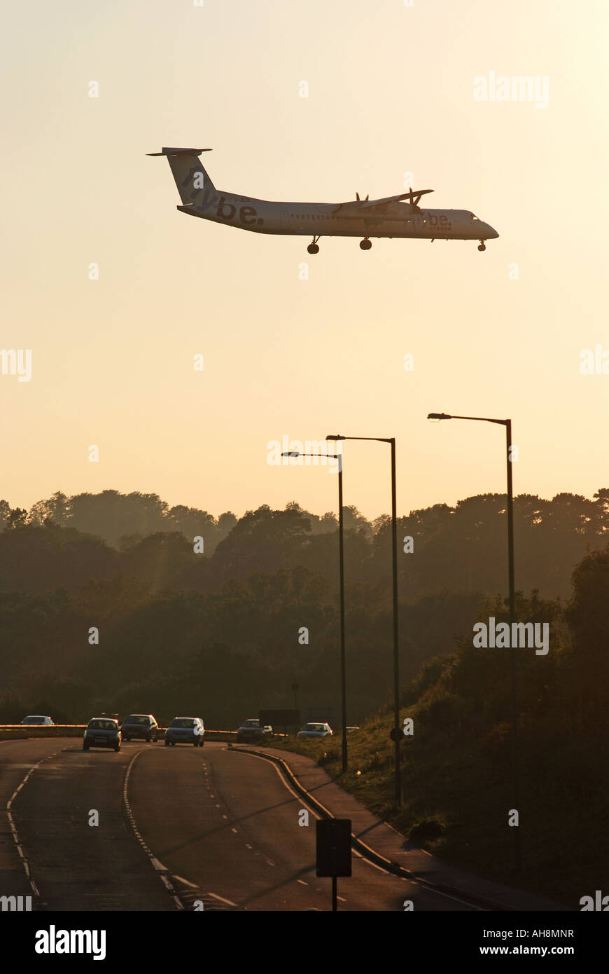 Flybe Dash Eight aircraft crossing A45 road at sunset to land at ...