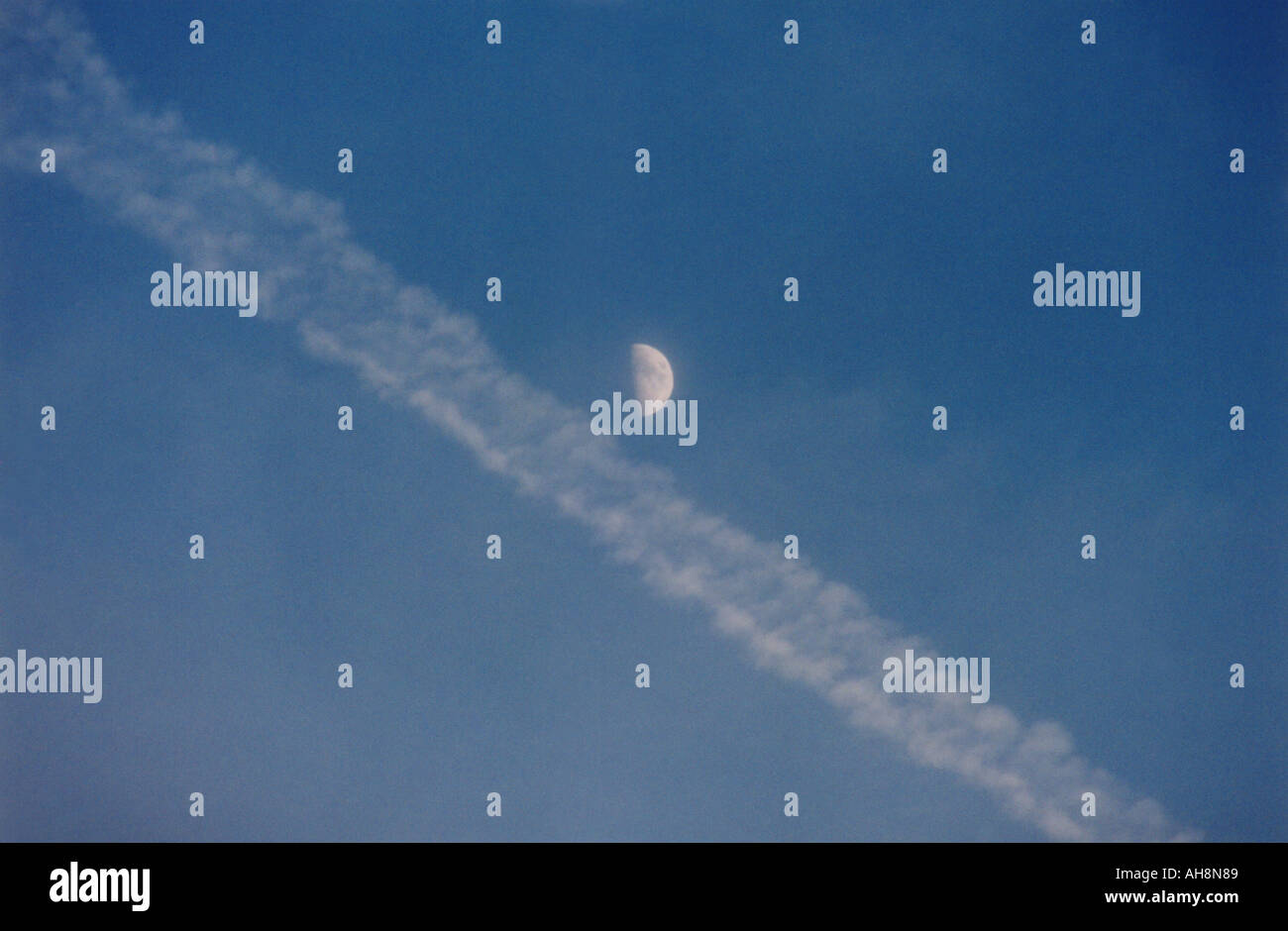 Half Moon and Contrail Stock Photo - Alamy