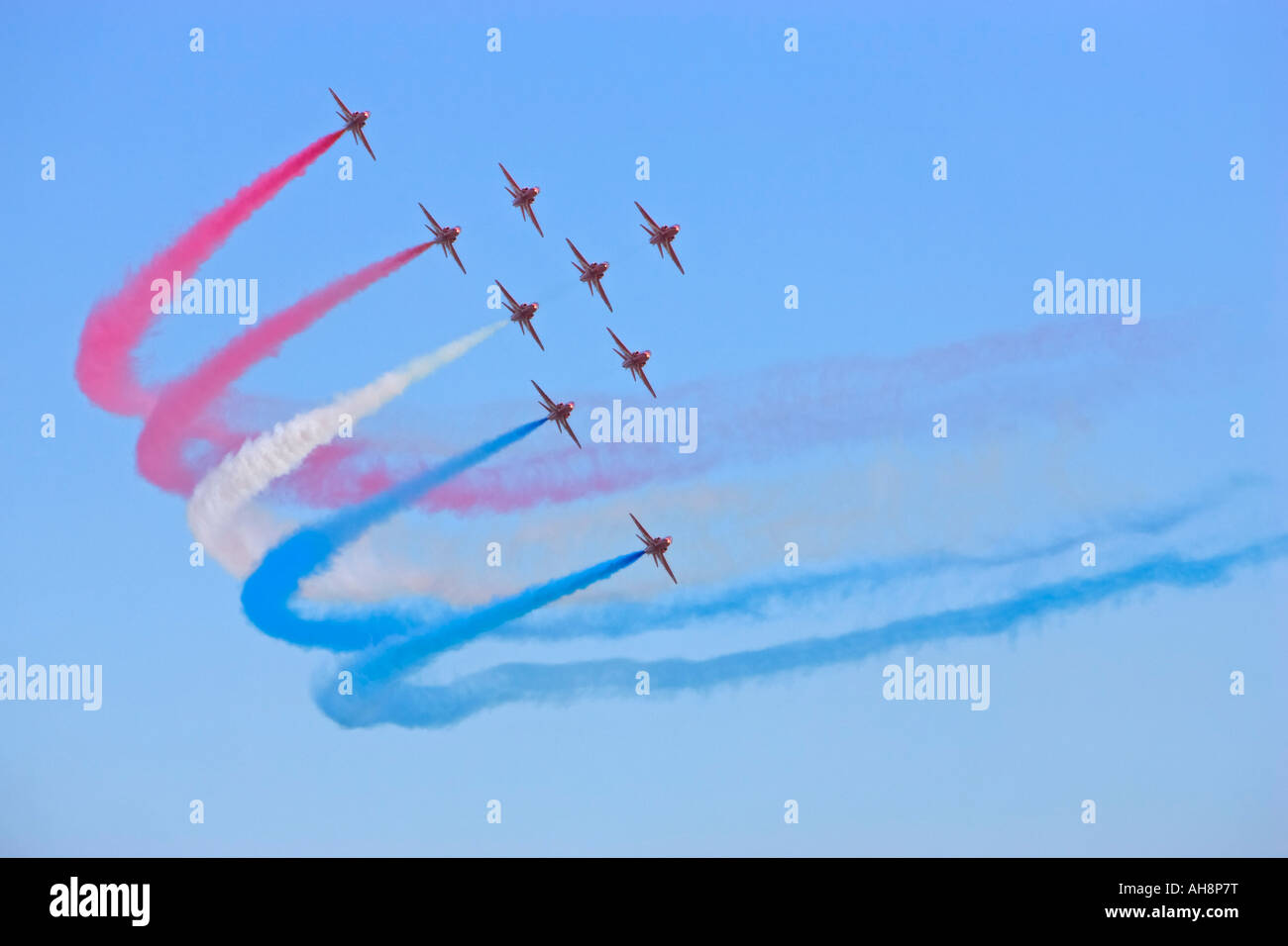 The Red Arrows flying in formation with Red White and Blue smoke trails ...