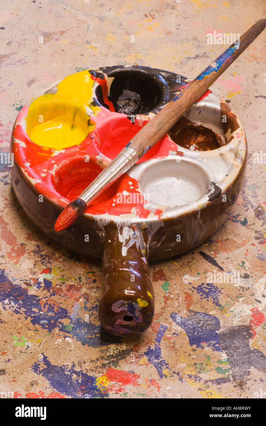 A paint brush and palette with brightly coloured paints Stock Photo - Alamy