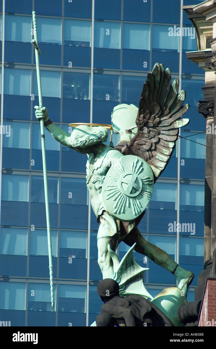 Statue of an angel in front of a modern facade of a commercial building ...
