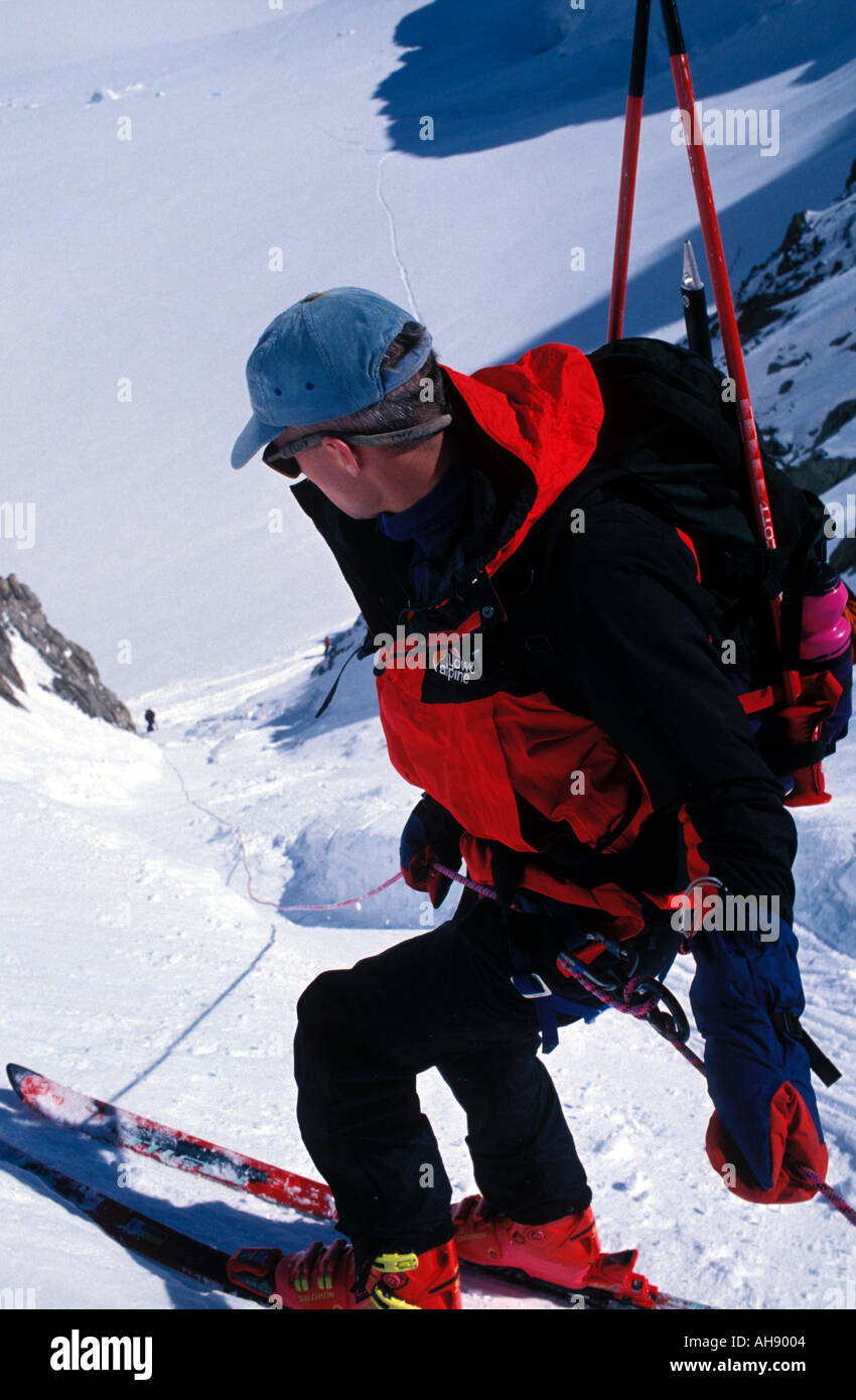 Mountain ski touring man abseiling down a narrow steep gully Stock ...