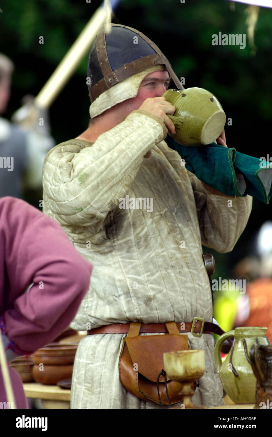 Man drinking jug of ale in encampment at re enactment of a medieval ...