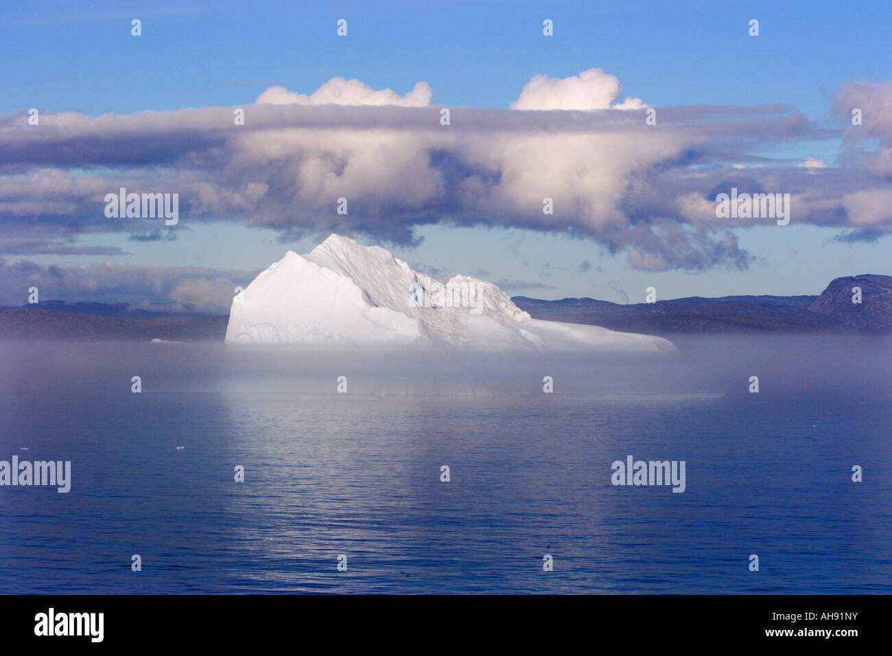 Huge iceberg with low sea fog around it and peak showing through in ...