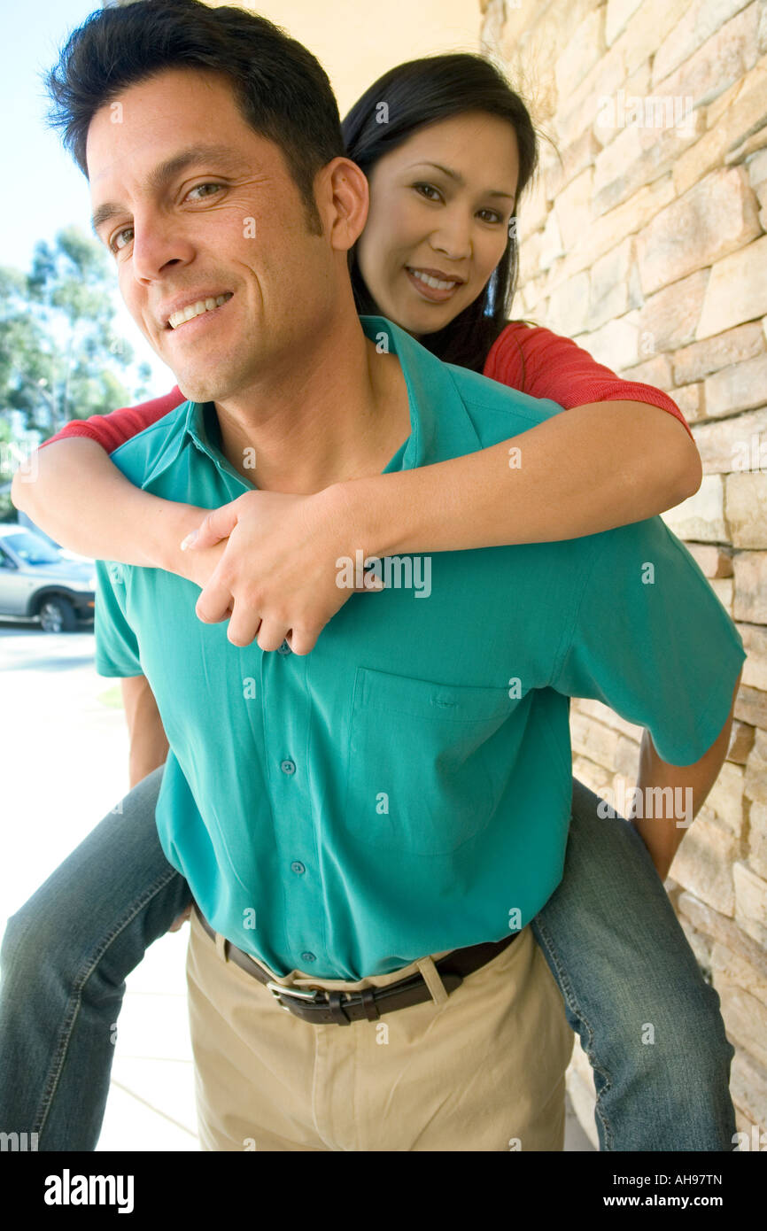 Portrait of a man giving a woman a piggy-back ride Stock Photo - Alamy