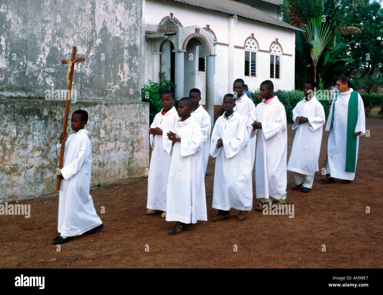 Roman Catholic altar boys and a priest in procession before Sunday Mass ...