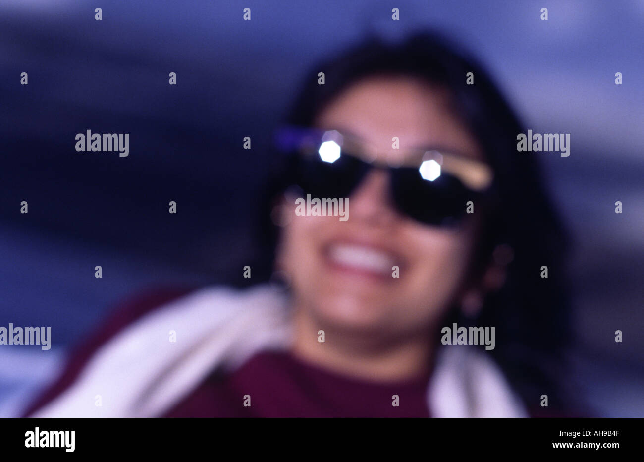 Portrait of young lady with cheesy smile slightly blurred out of focus ...