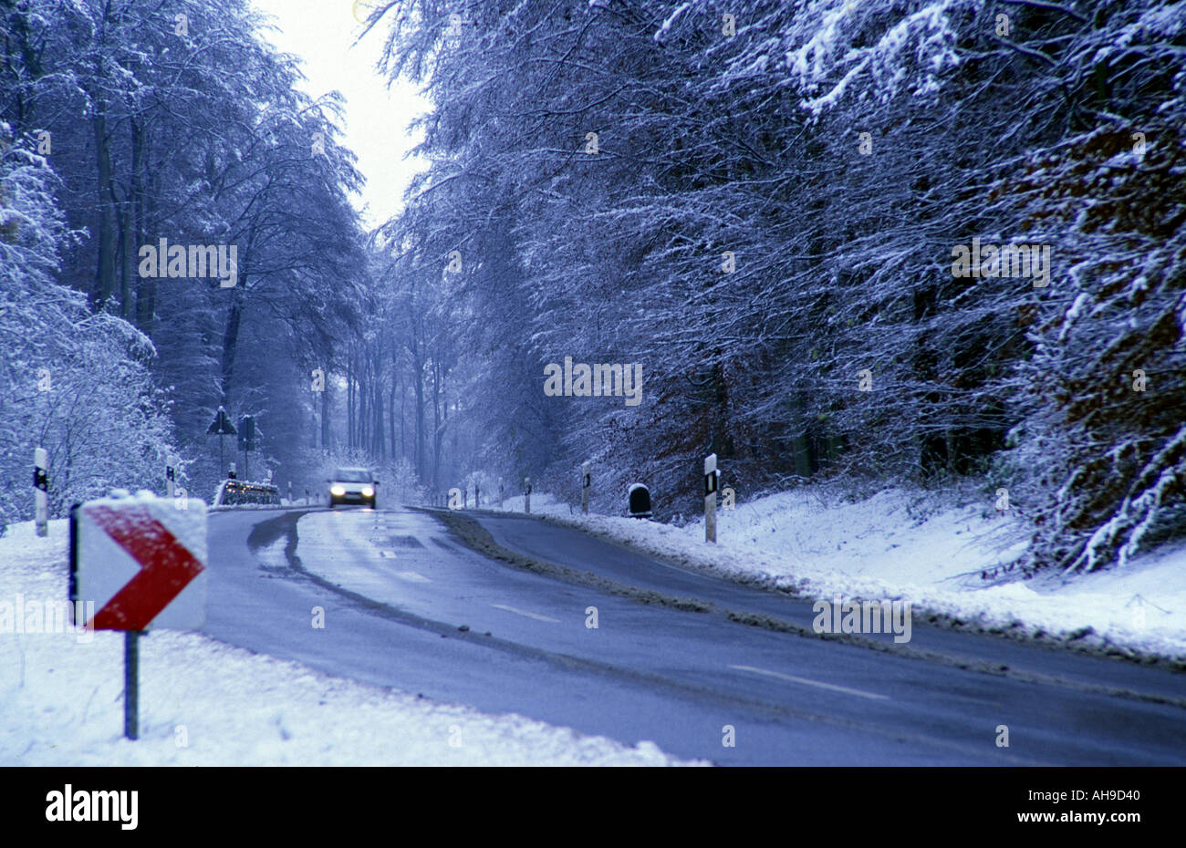a car in a curve of a snow covered country road Stock Photo - Alamy