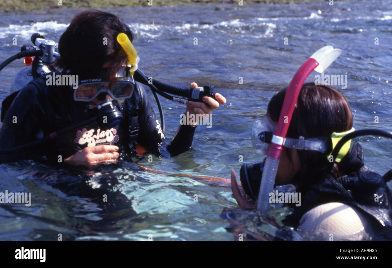 Japanese dive student gets a lesson from diving instructor Okinawa ...