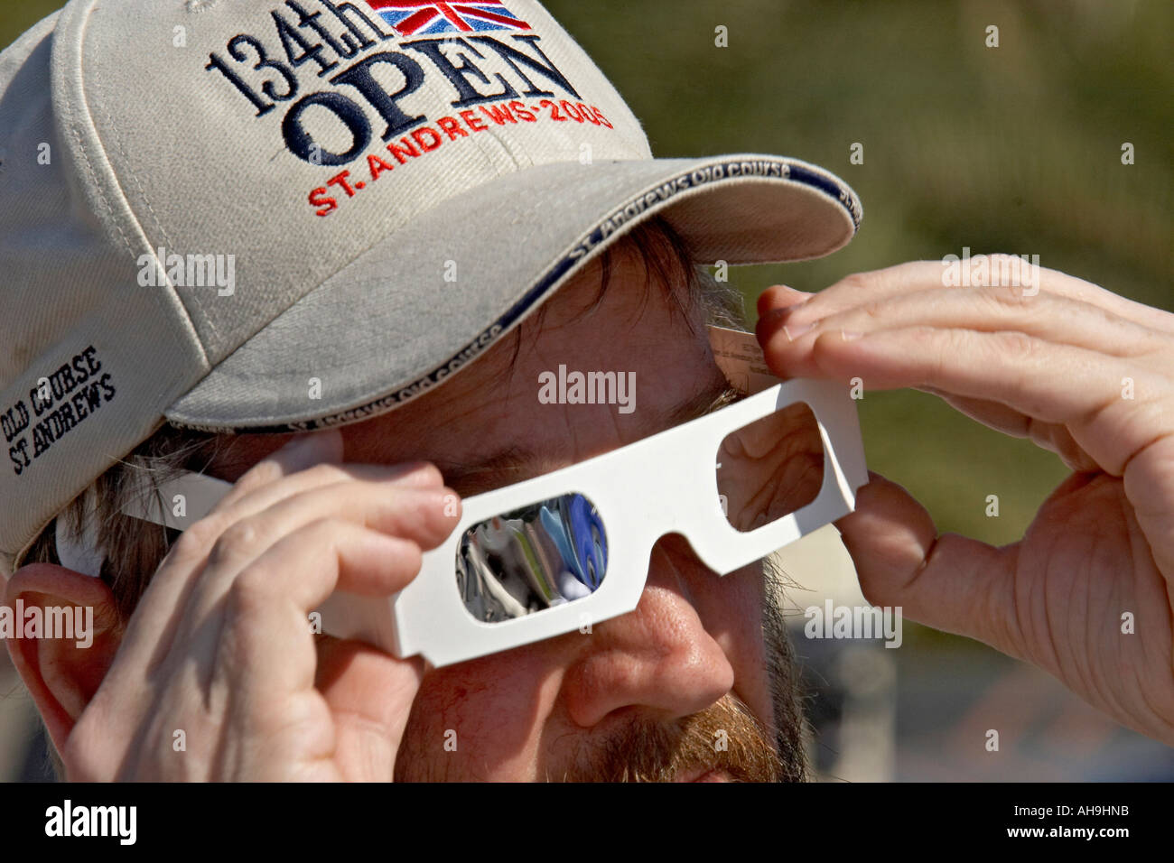 Man with solar viewer safety glasses watching the initial stages of the ...