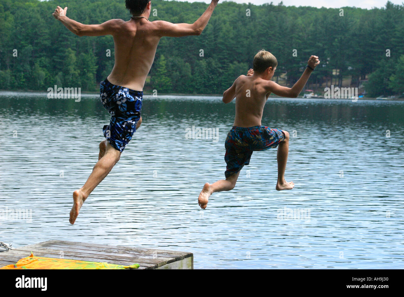 Boys Jumping Off Dock Stock Photo - Alamy