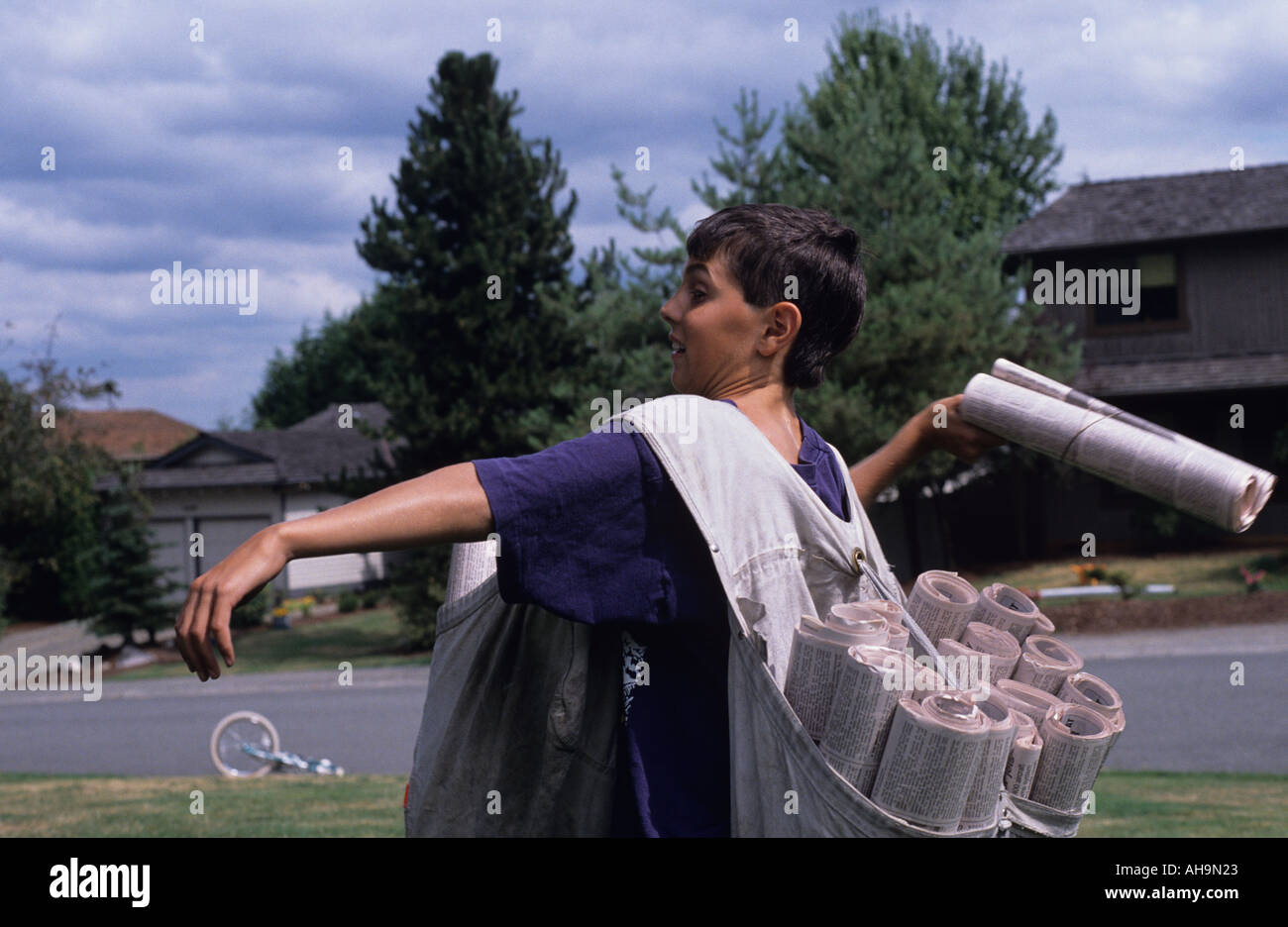 Young boy nine years old delivering papers on his route Washington USA ...