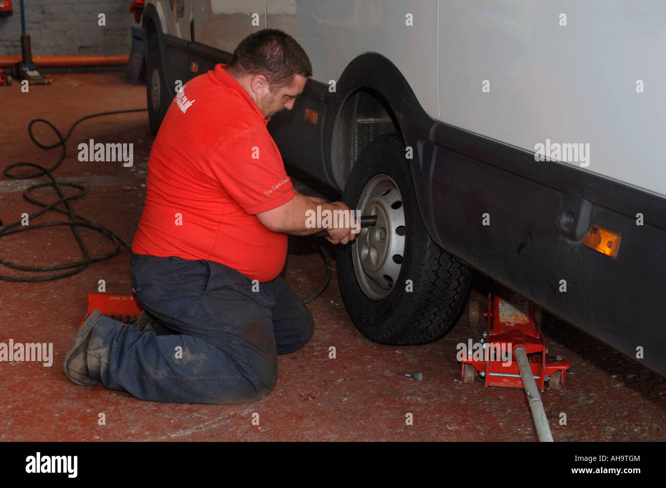 A Man Fixing Wheel Back Onto A Van Stock Photo - Alamy