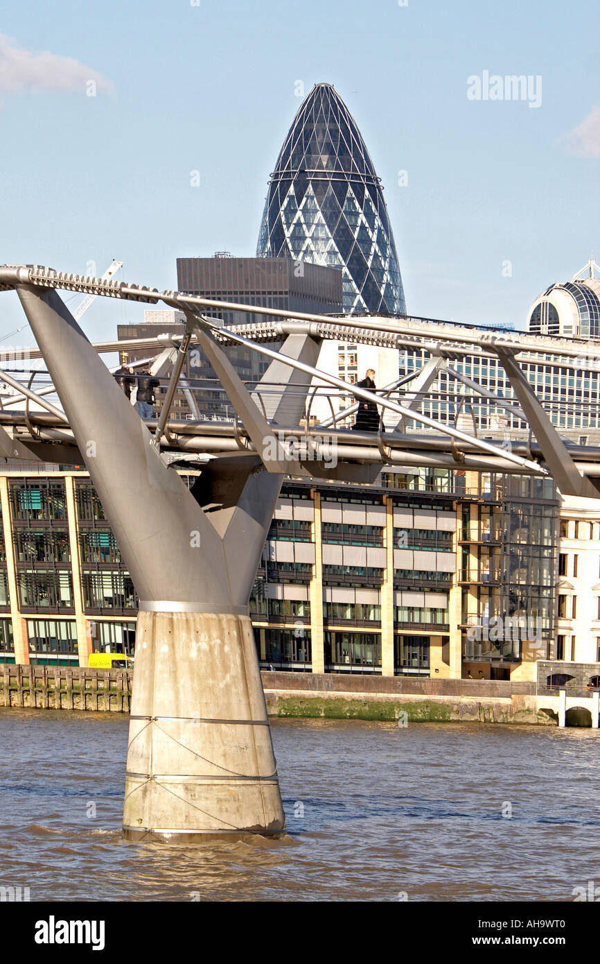 People walking across Millenium Bridge over with River Thames with ...
