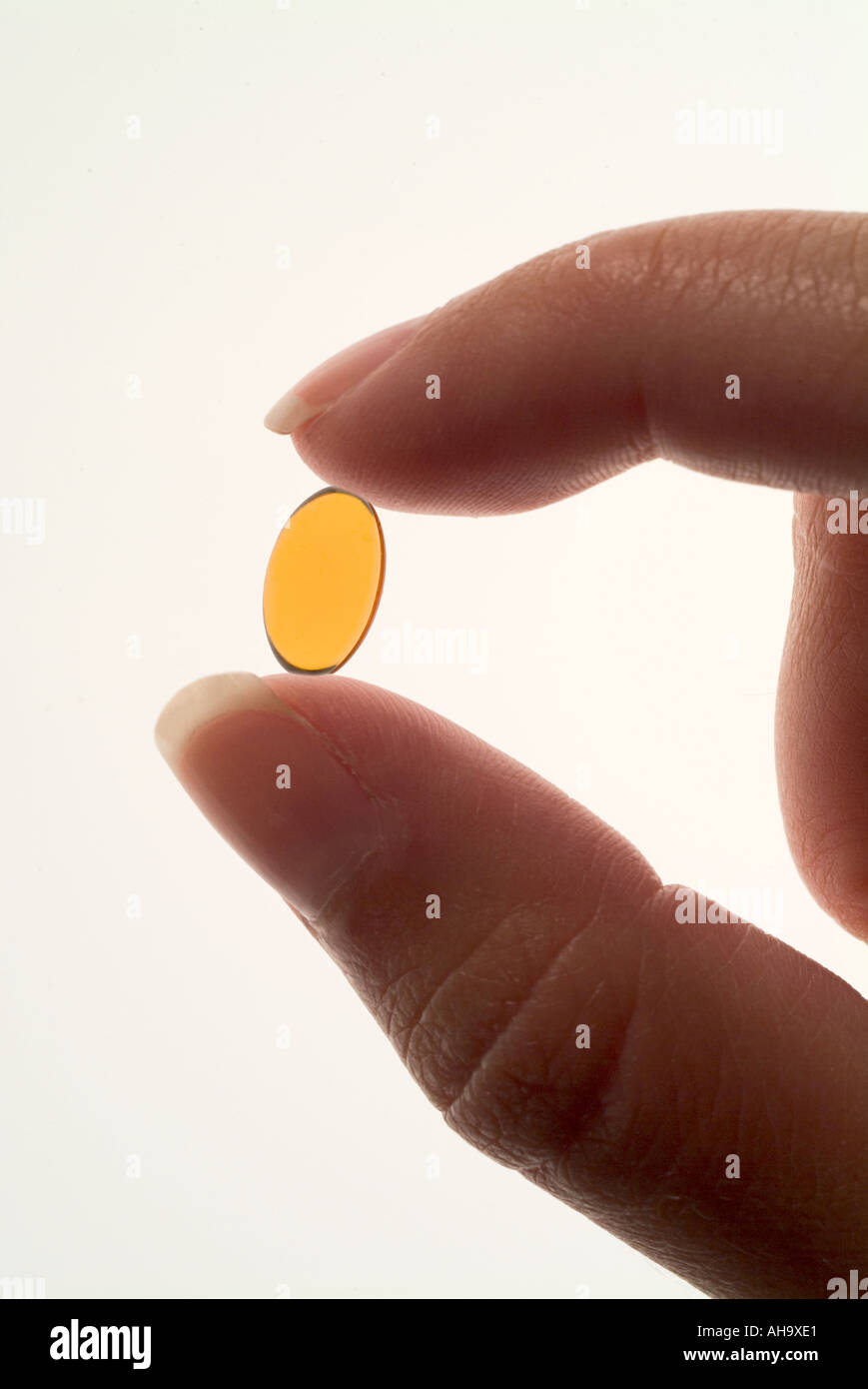 Fingers holding capsule Stock Photo - Alamy