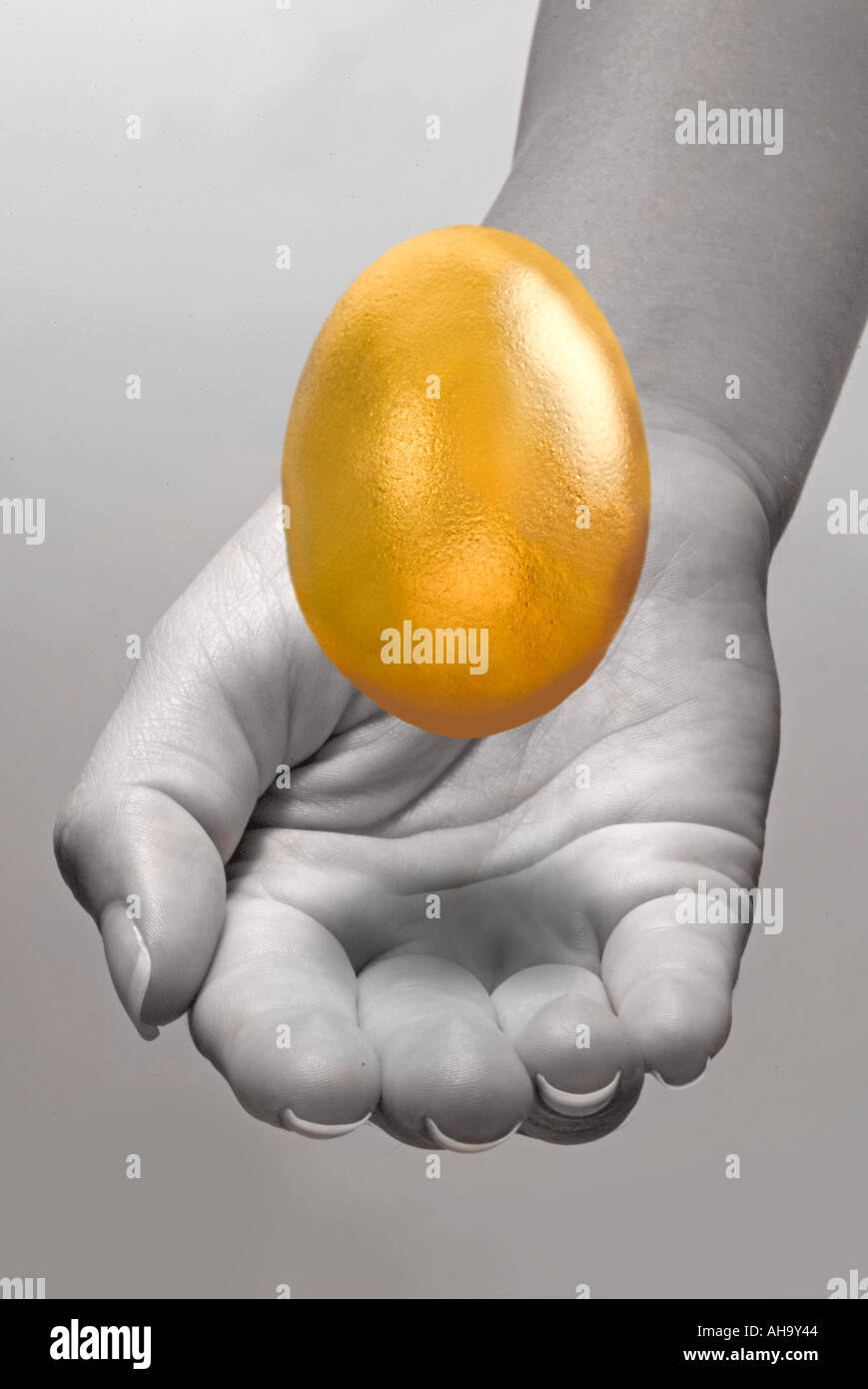Golden egg floating over hand Stock Photo - Alamy