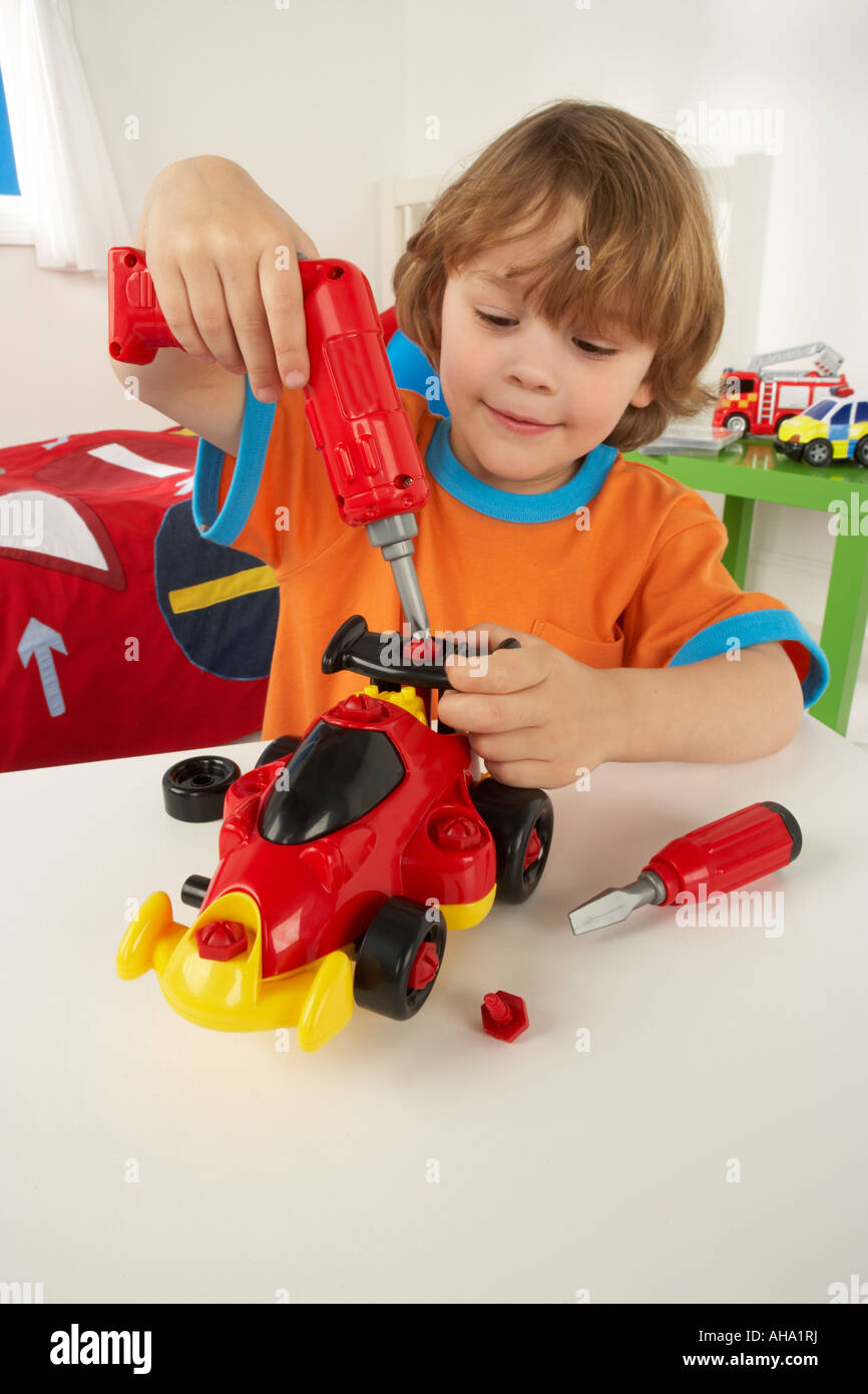 boy playing and fixing his toy racing car in his bedroom Stock Photo ...