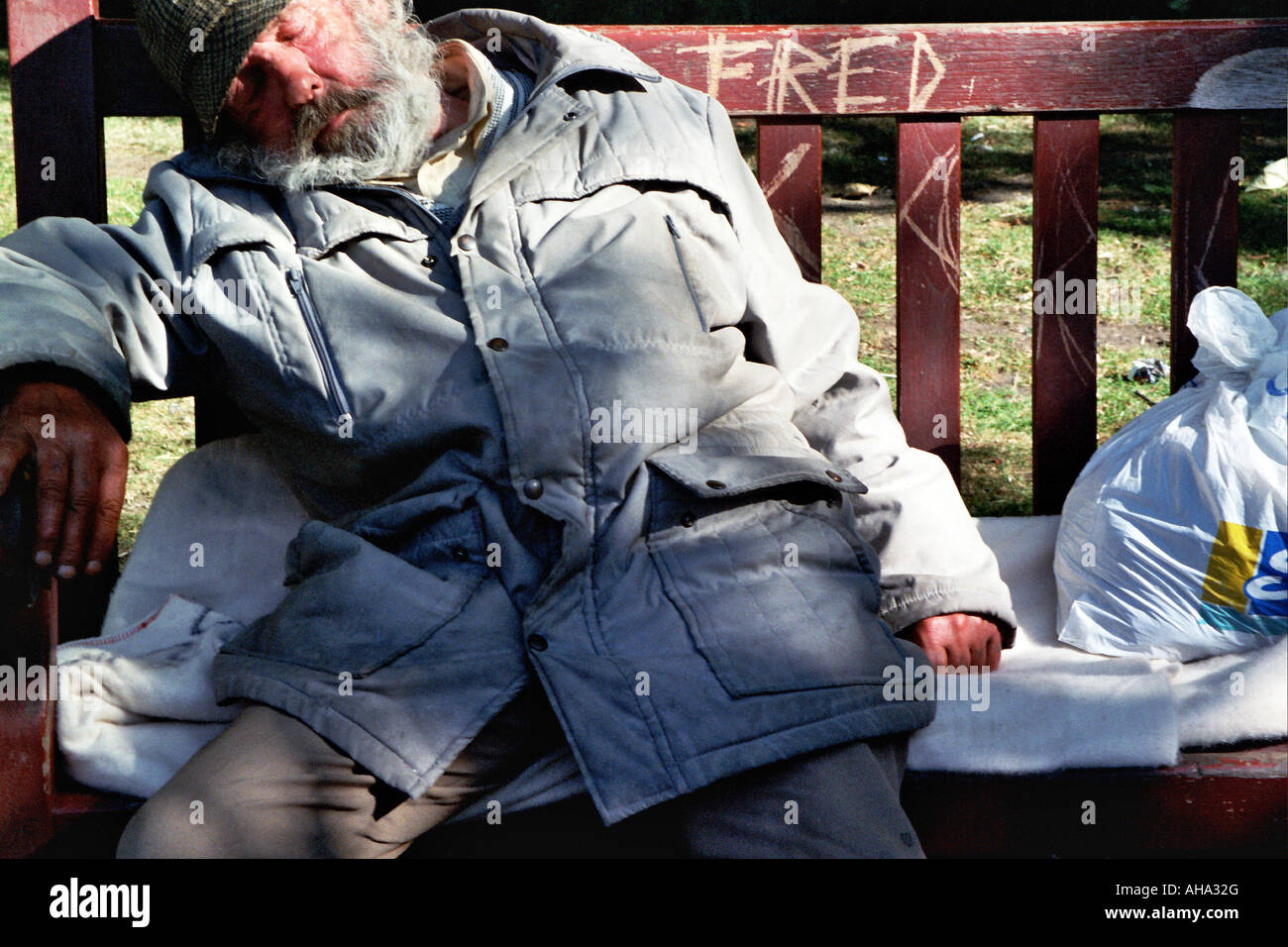 Man asleep on bench in park Stock Photo - Alamy
