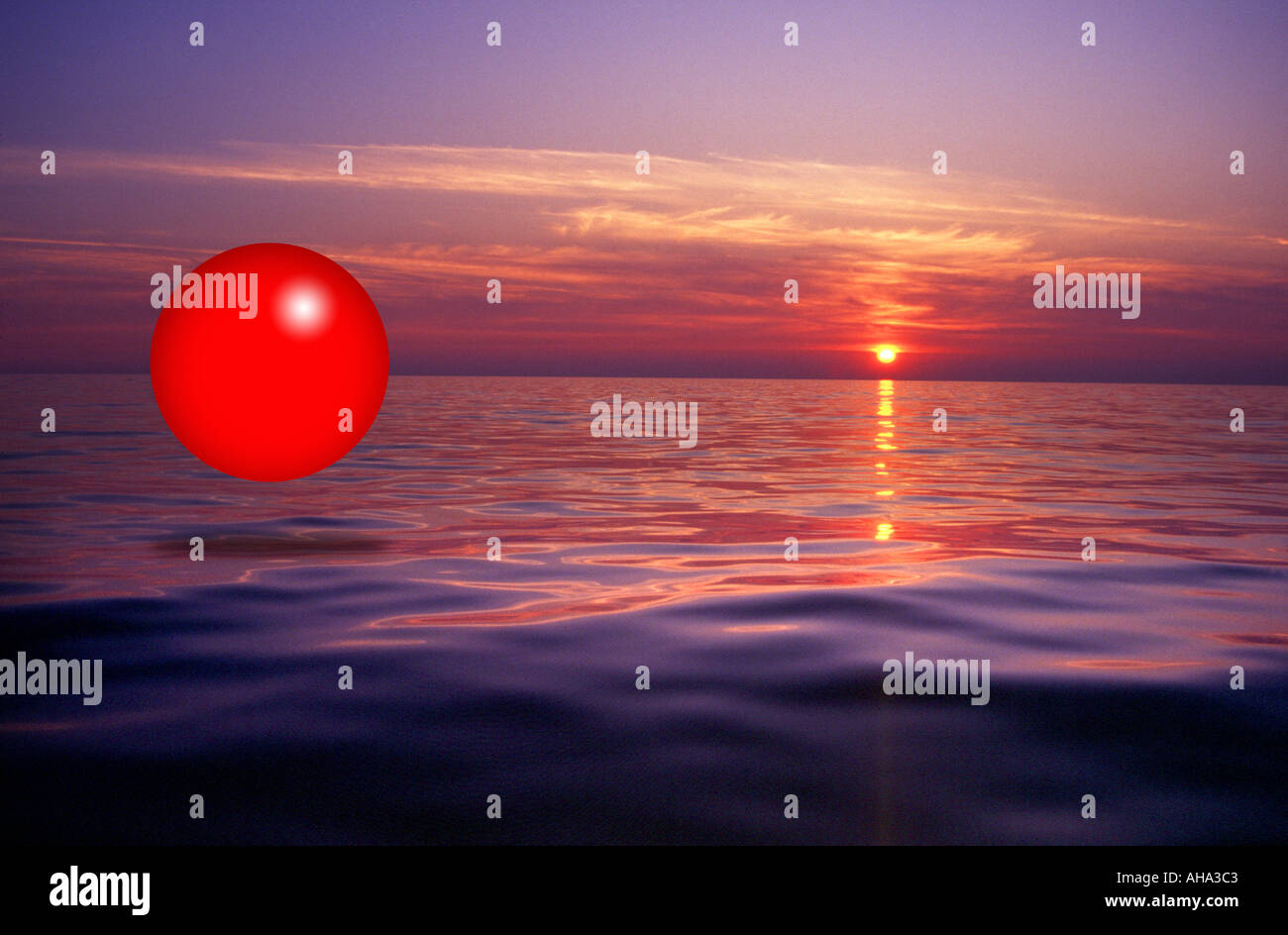 sunrise over sea with floating red sphere Stock Photo - Alamy