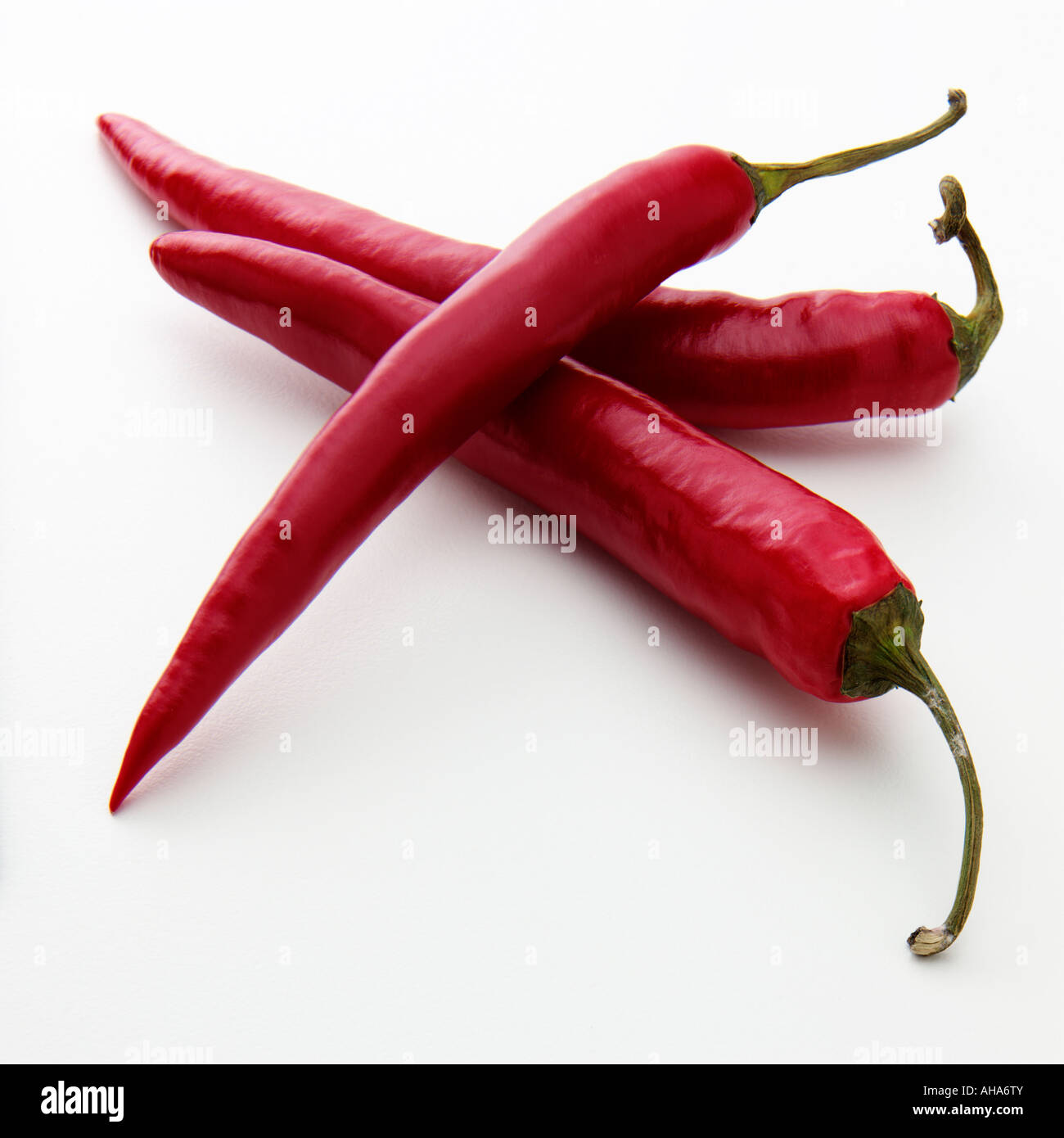 Three red chillies on a white background editorial food Stock Photo - Alamy
