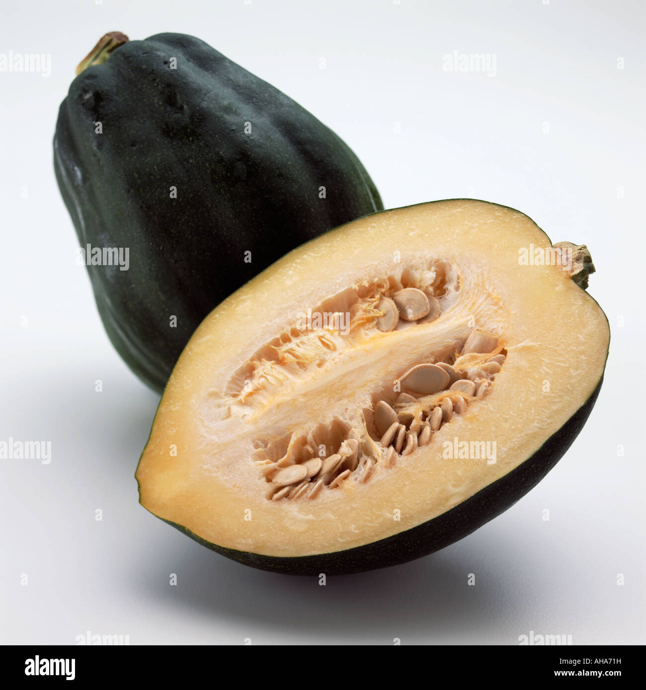 A whole and a half acorn squash on a white background editorial food ...