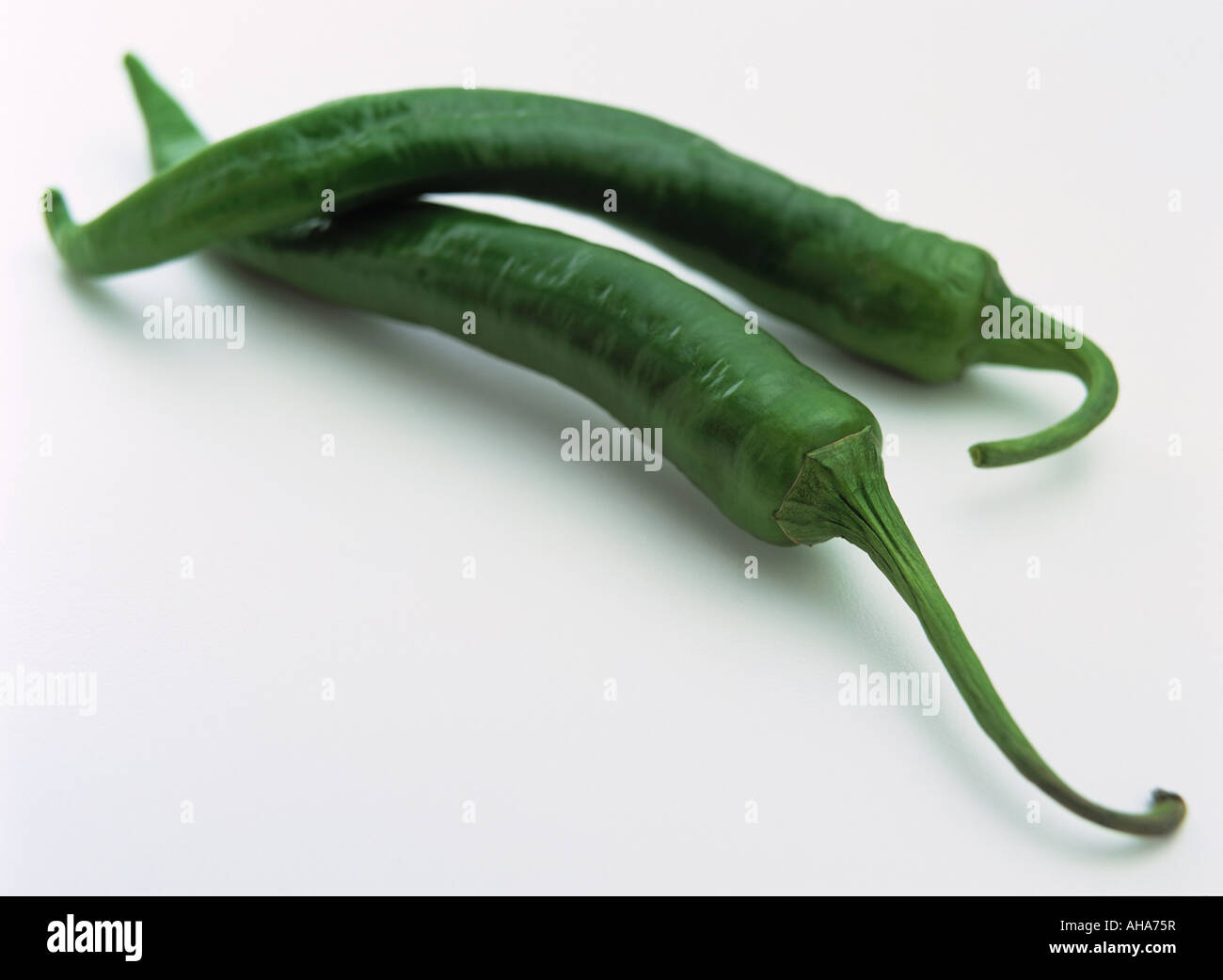 Two green chillies on a white background editorial food Stock Photo - Alamy