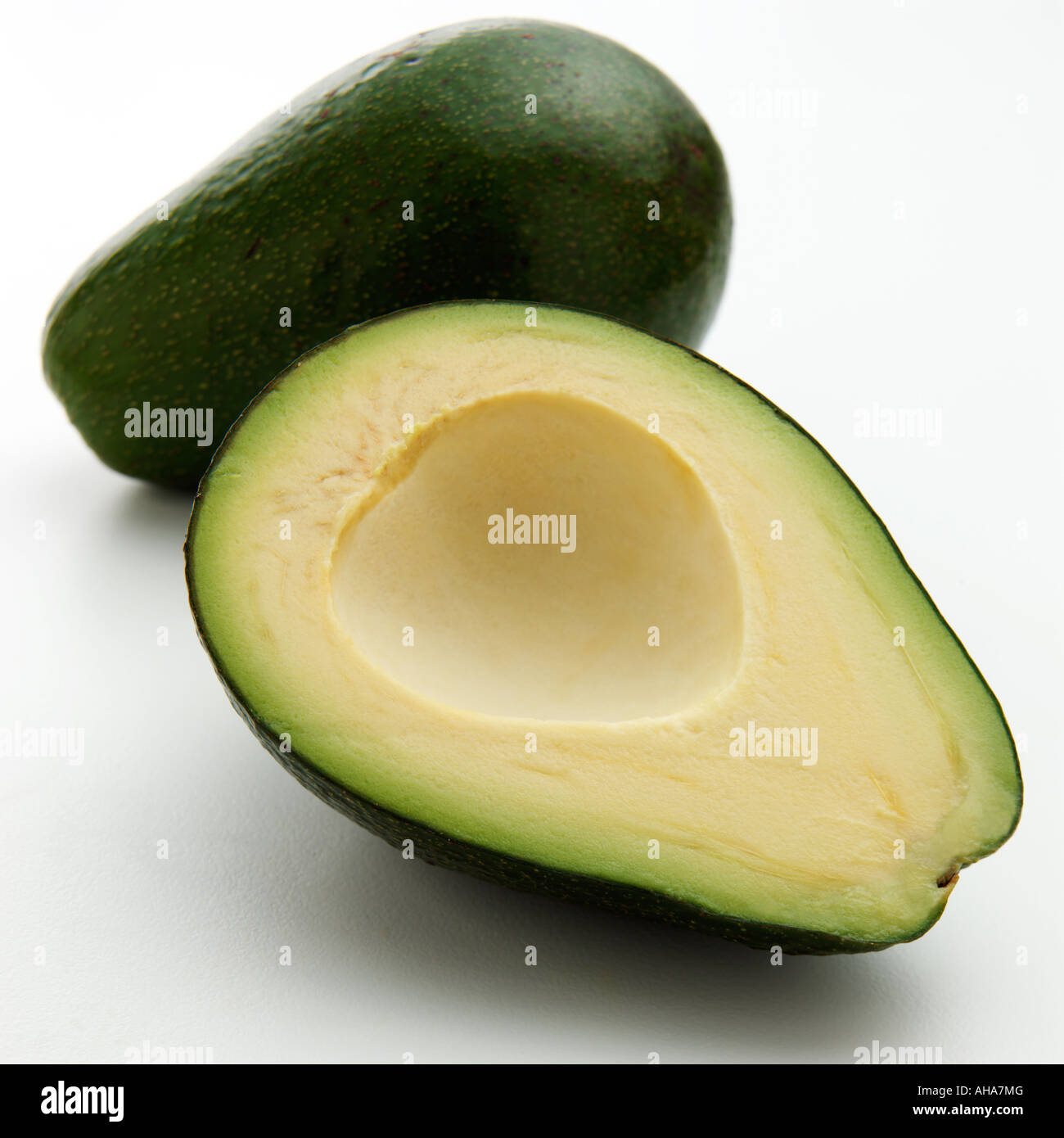 A whole and a half avocado on a white background Stock Photo - Alamy