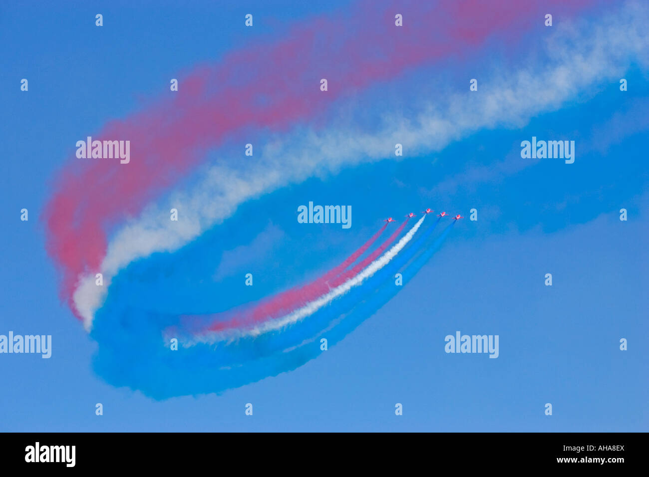 The Red Arrows flying in formation with Red White and Blue smoke trails ...