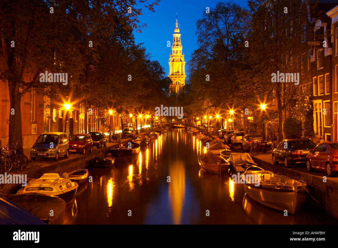 View of Zuiderkerk along Groenburgwal canal at night with reflections ...