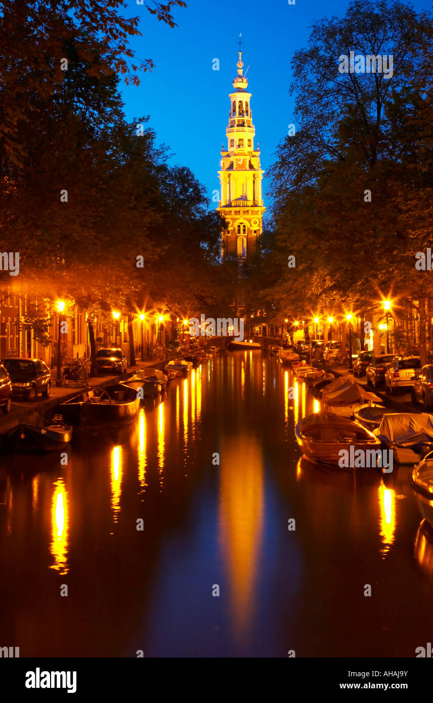 View of Zuiderkerk along Groenburgwal canal at night with reflections ...