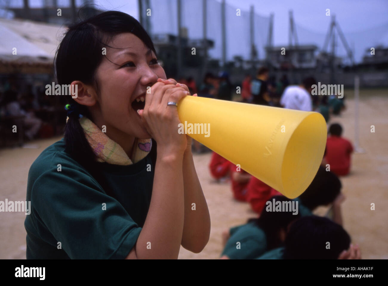 Japanese high school girl yells through the megaphone cheering on her ...
