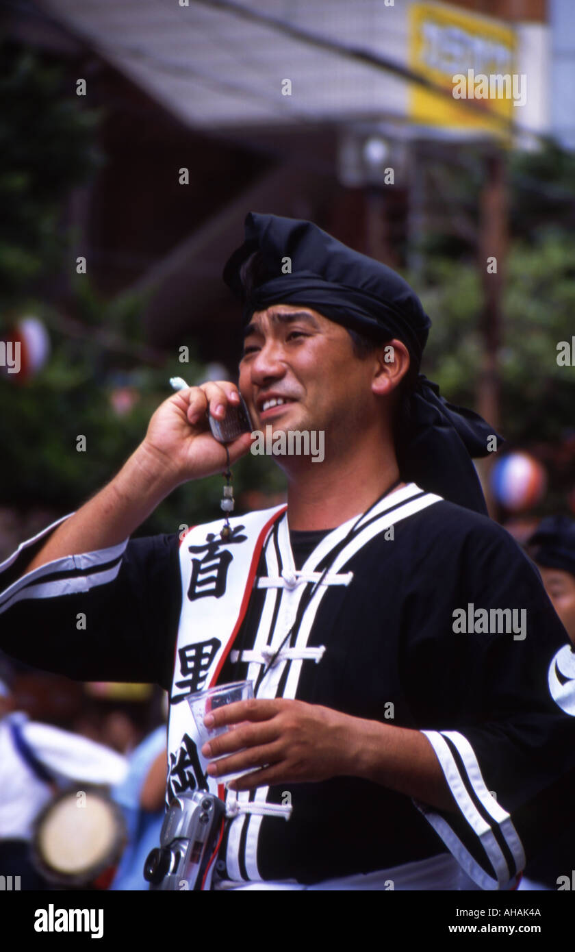 Okinawan man using modern technology during an ancient Eisa festival ...