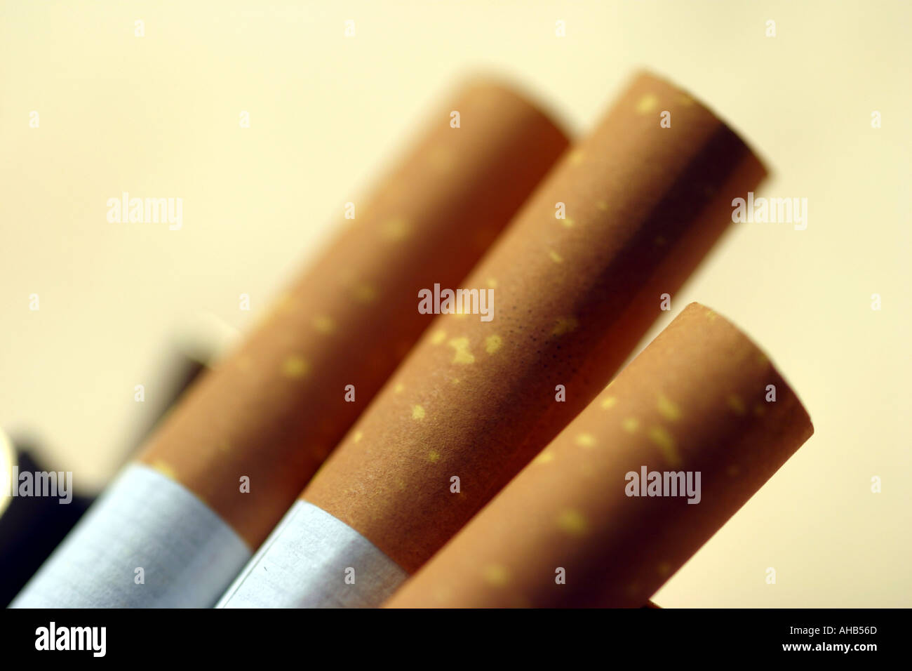 Three cigarettes in a packet on a yellow background Stock Photo - Alamy