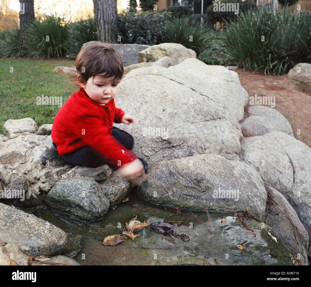 Child playing with tree branch in a stream Stock Photo - Alamy