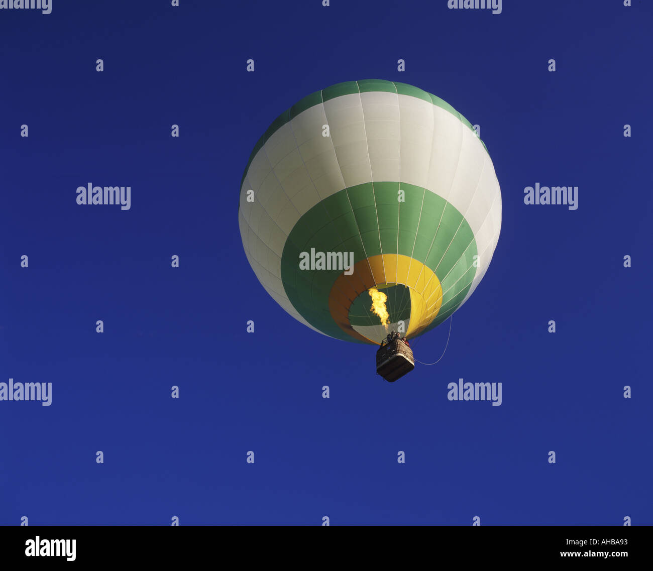 Hot air balloon rising in blue sky Stock Photo - Alamy